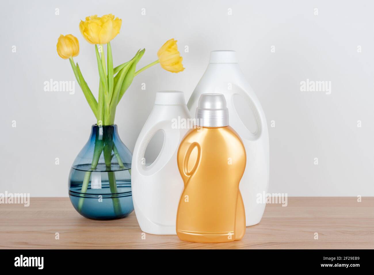 Bottles of detergent and fabric softener with yellow tulip flowers on ...