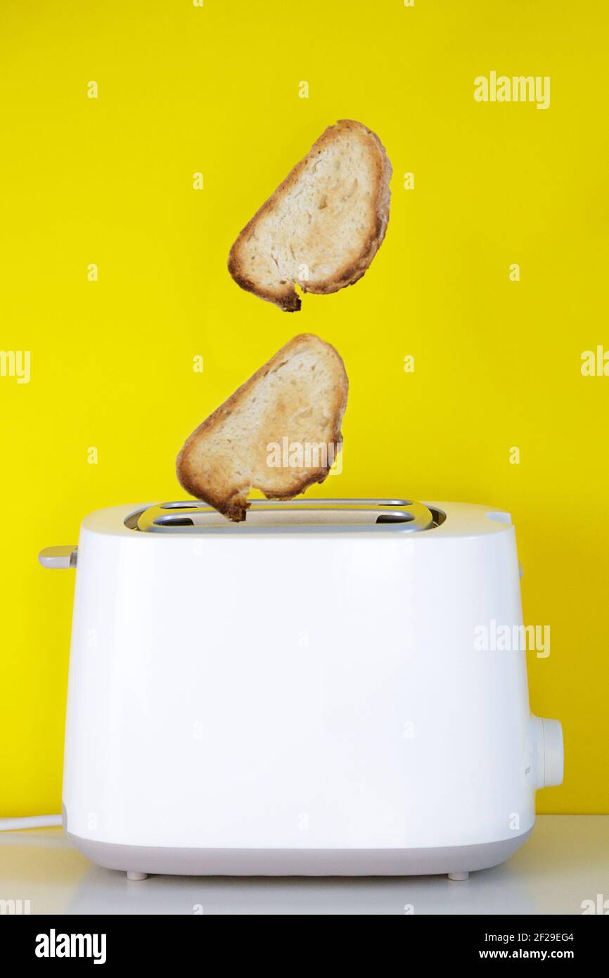 Slices of toast jumping out of the toaster against yellow background ...