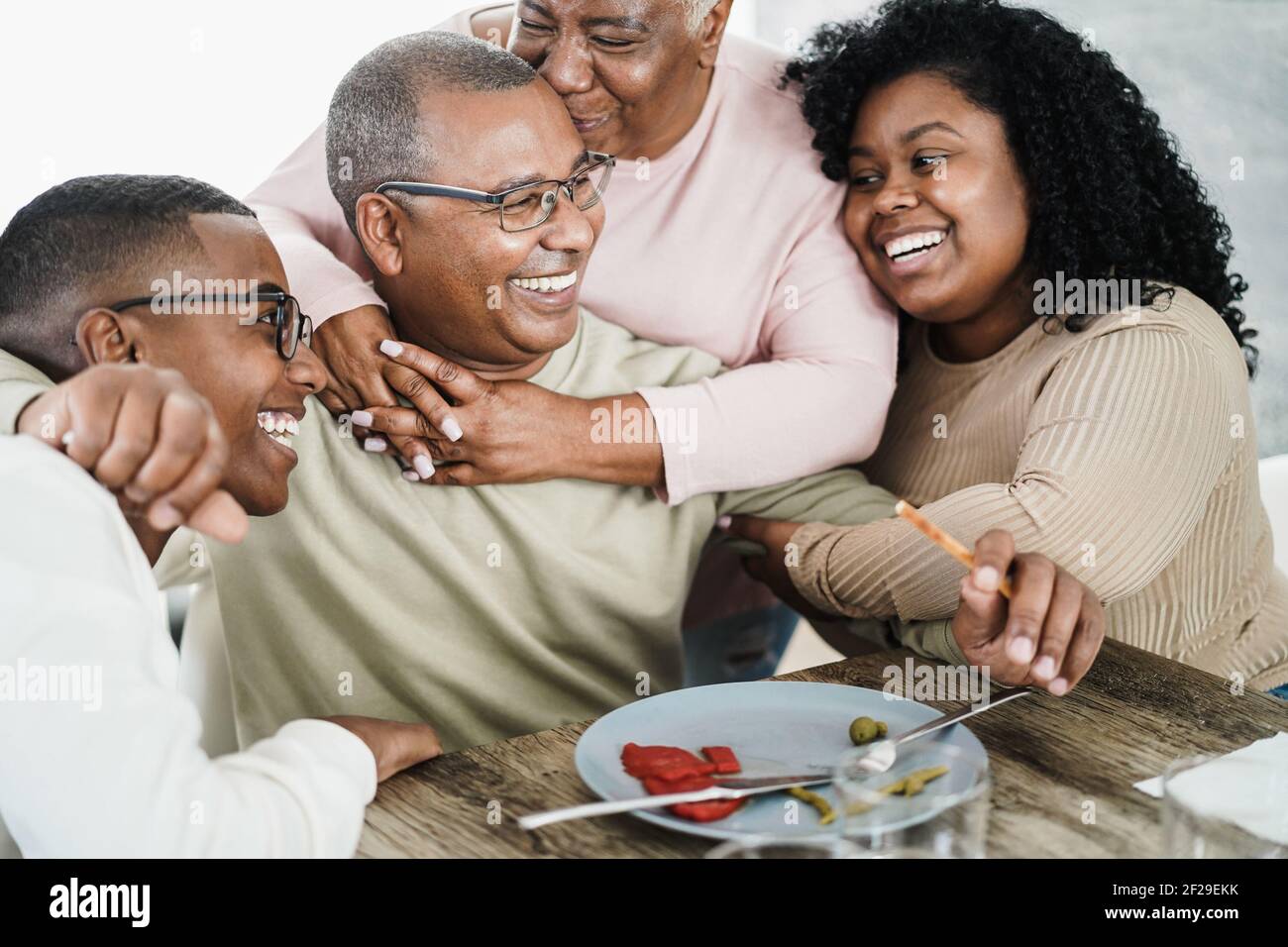 Happy black family eating lunch at home - Father, daughter, son and ...