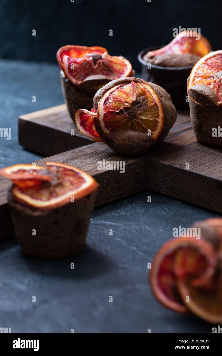 Blood oranges chocolate brownie muffins at brown oak cutboard on dark ...