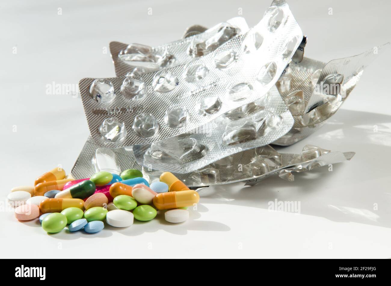 group of pills and silver empty pills blister isolated Stock Photo - Alamy