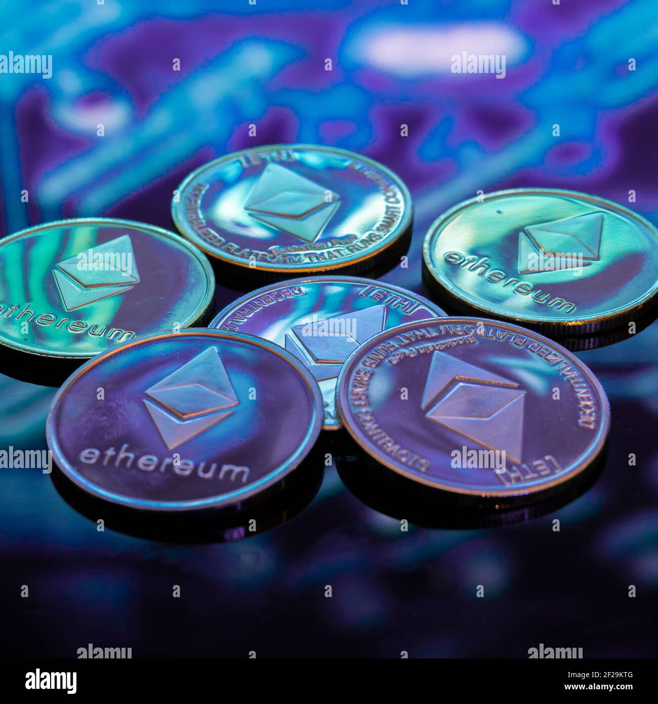 Ethereum gold, silver and copper coins and defocused printed circuit ...