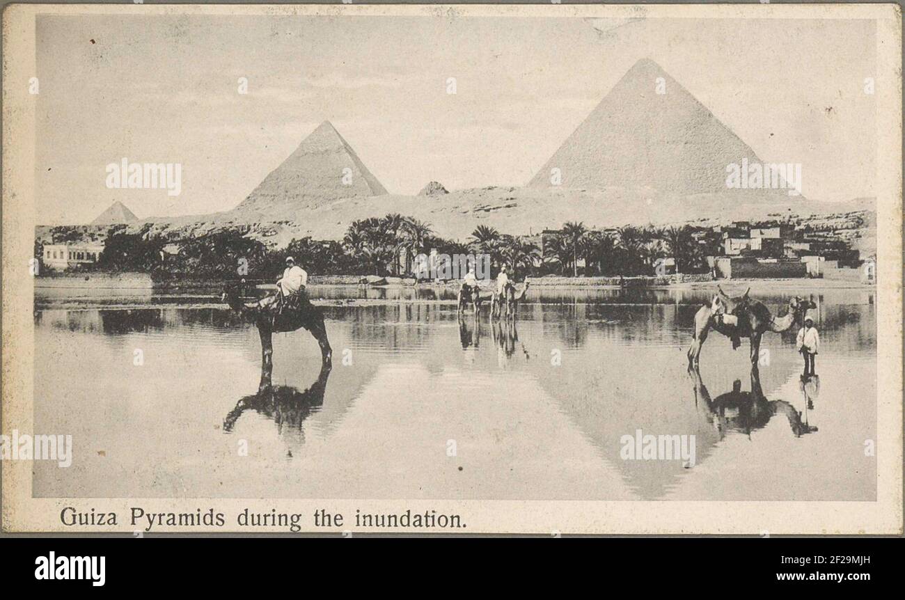 Pyramids of Giza during flooding, in the foreground men on camels ...