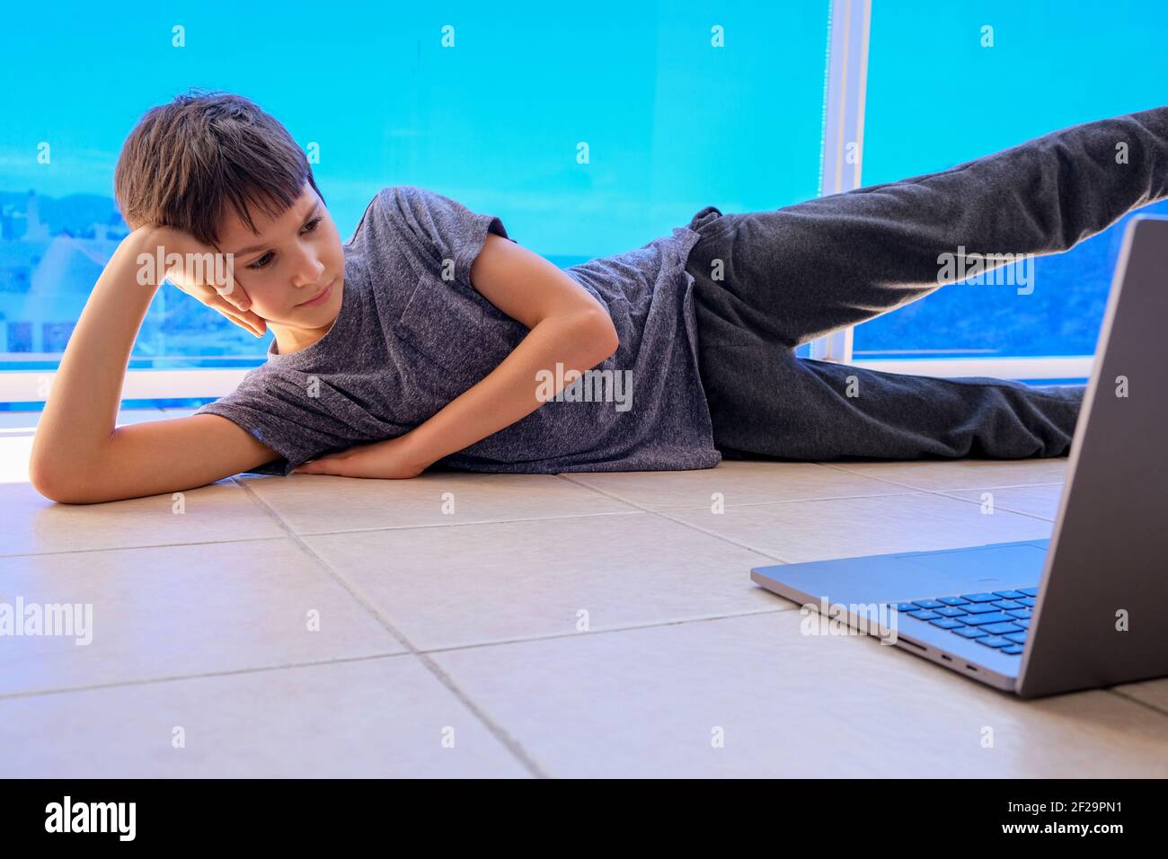Child watching online video on laptop computer and doing sport fitness ...