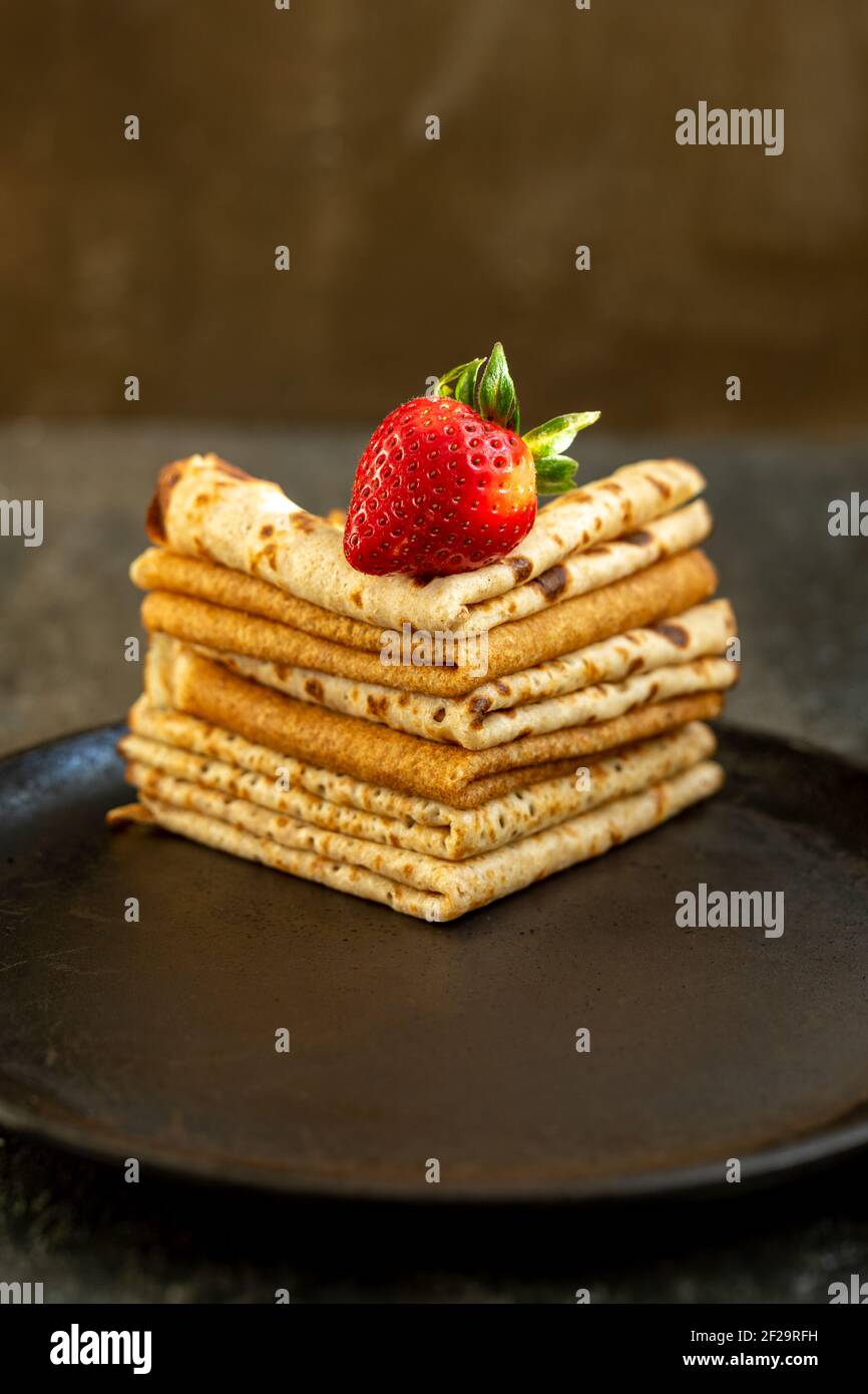 Tasty homemade rustic pancake with berries in a frying pan on wooden ...