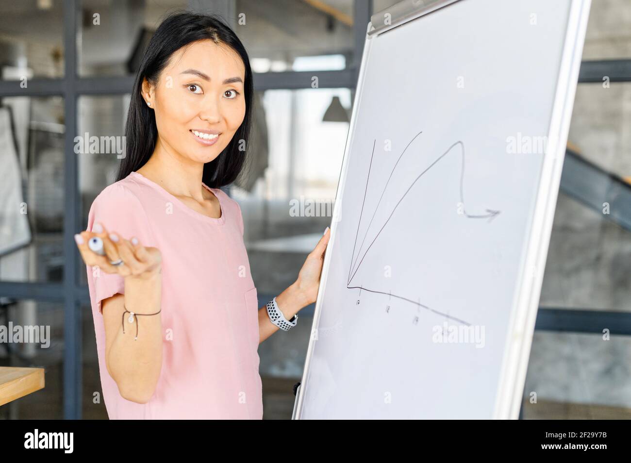 Modern pretty young Asian female school teacher streaming lesson online ...