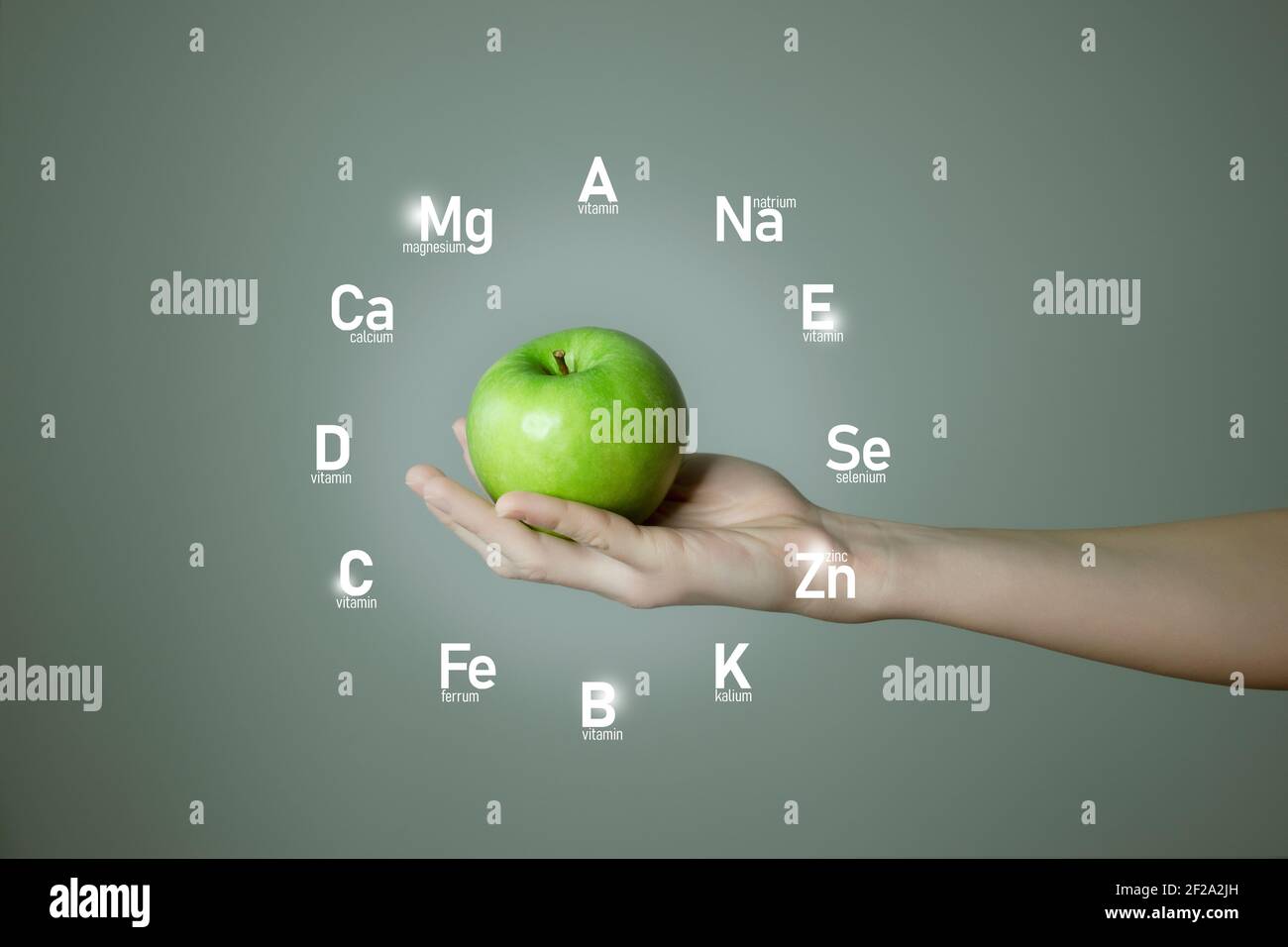 Woman`s hand holding green apple, microelement icons in clockface ...