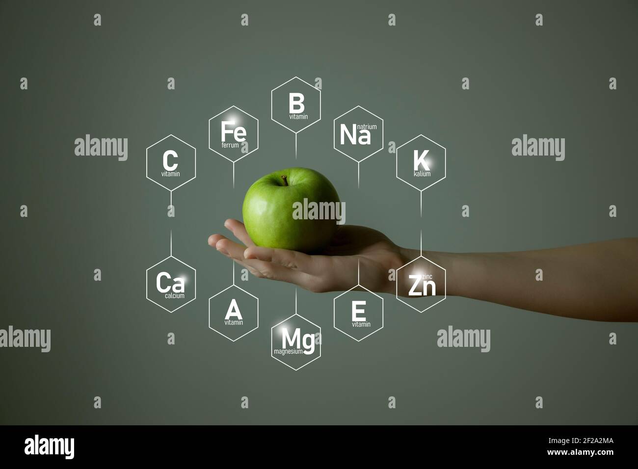 Woman`s hand holding green apple, microelement icons in molecular ...