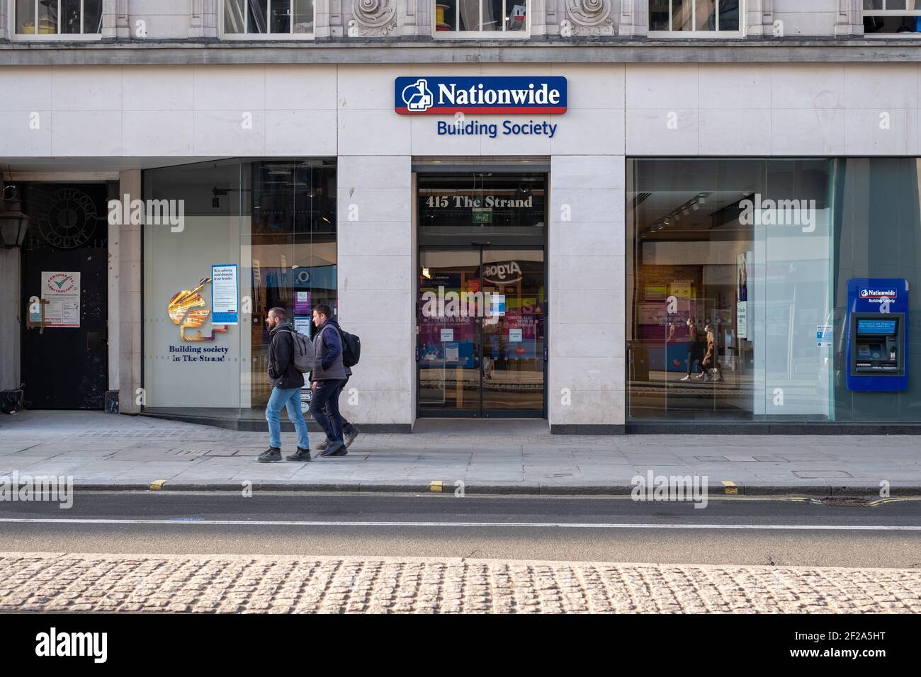 Two men walk past a branch of the Nationwide Building Society on The ...