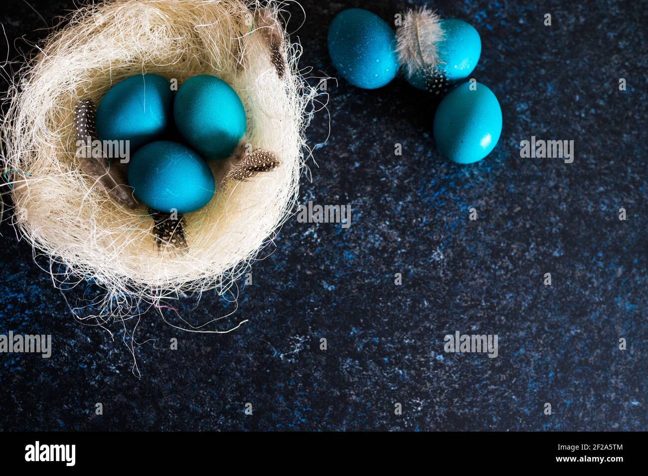 Easter turquoise eggs with twigs in a decorative nest on blue ...
