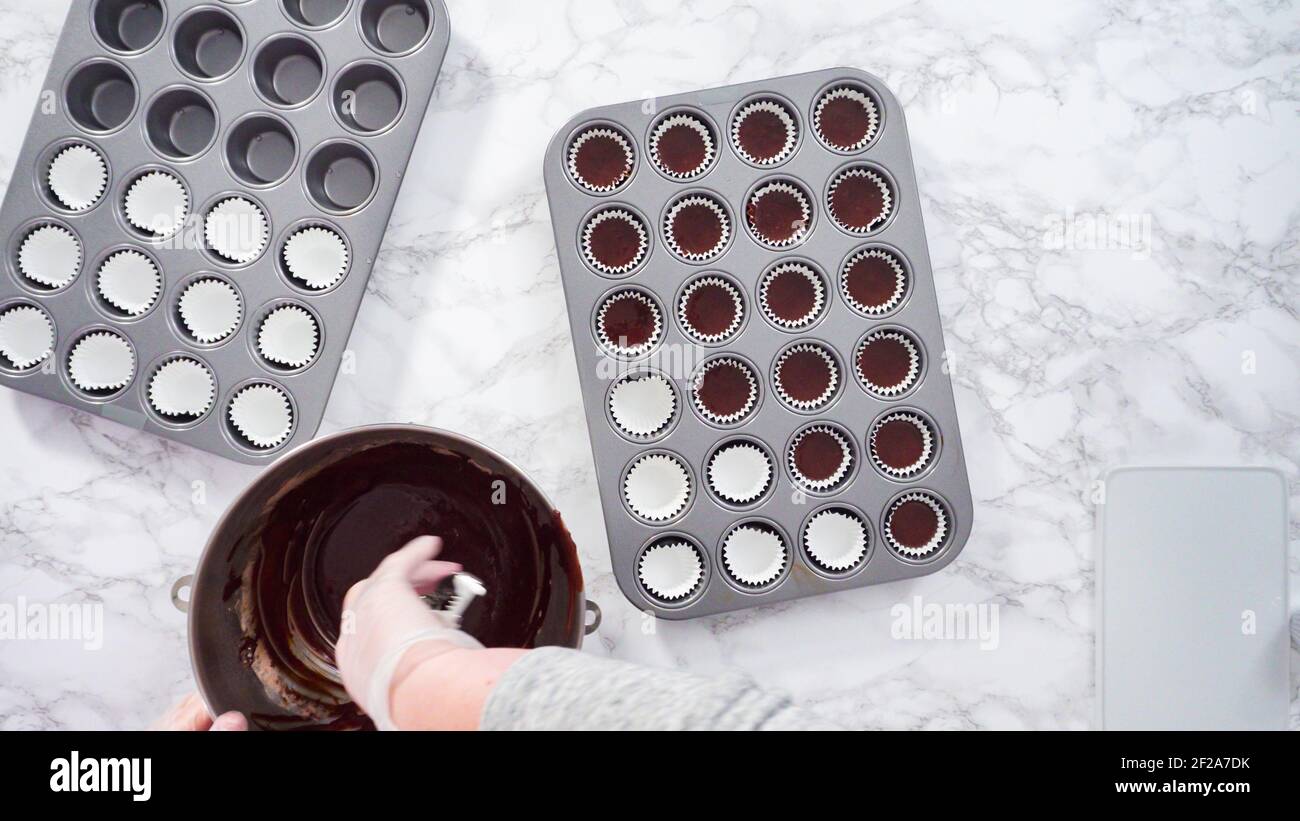 Flat lay. Step by step. Scooping cupcake batter into mini cupcake lines ...