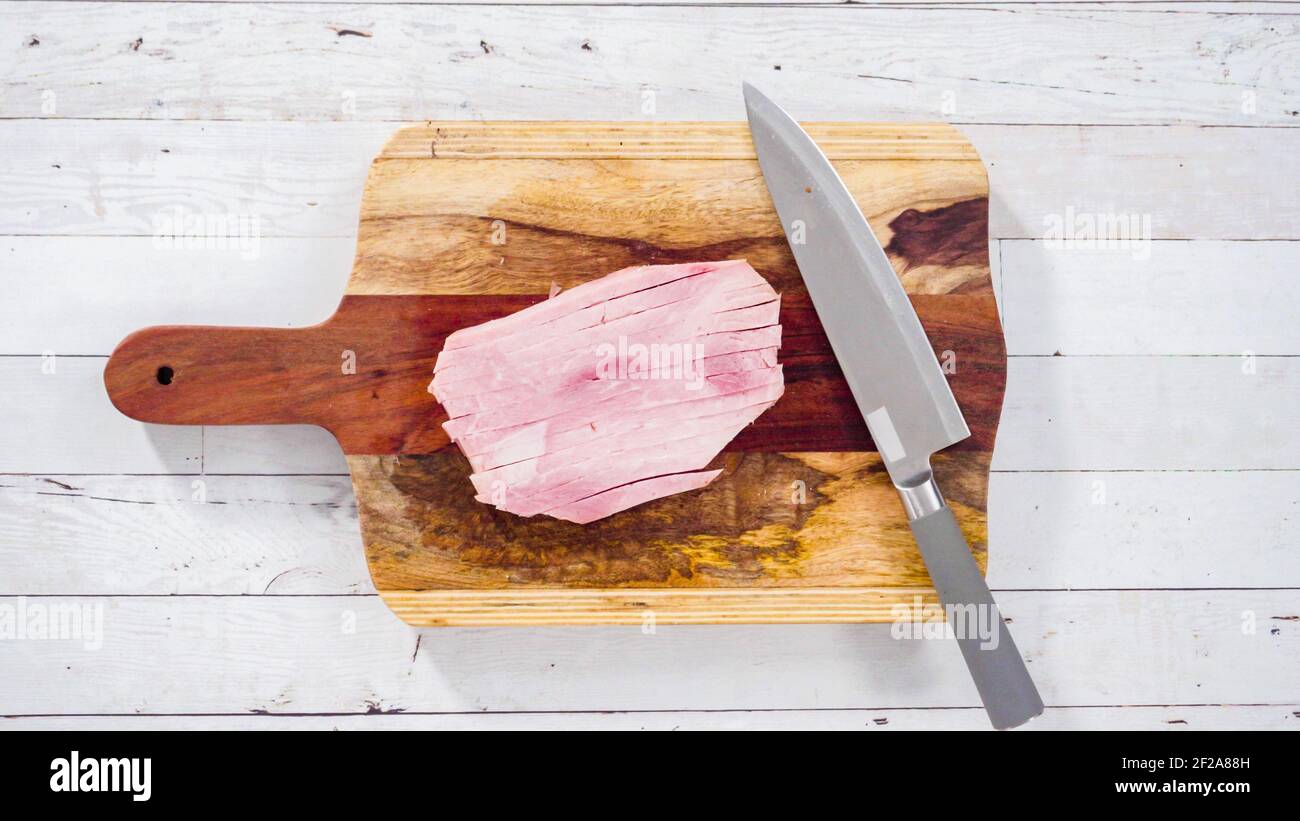 Flat lay. Cutting organic honey ham on a wood cutting board Stock Photo ...