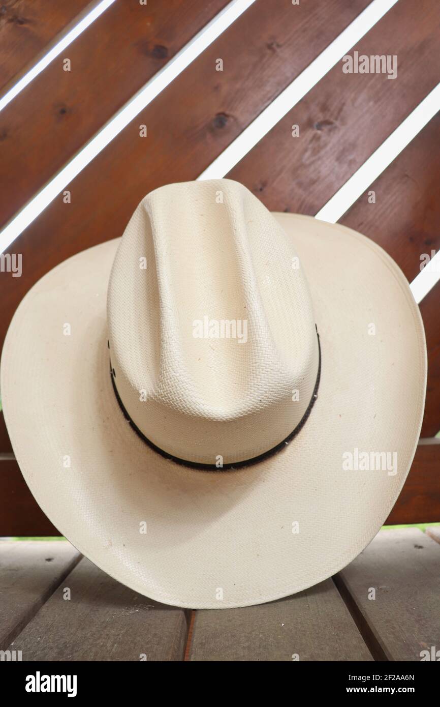 Straw cowboy hat leaning against brown wooden slats Stock Photo - Alamy