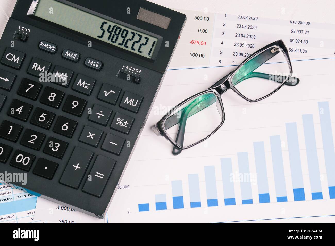 Papers with numbers and a calculator close-up. Work table with growth ...