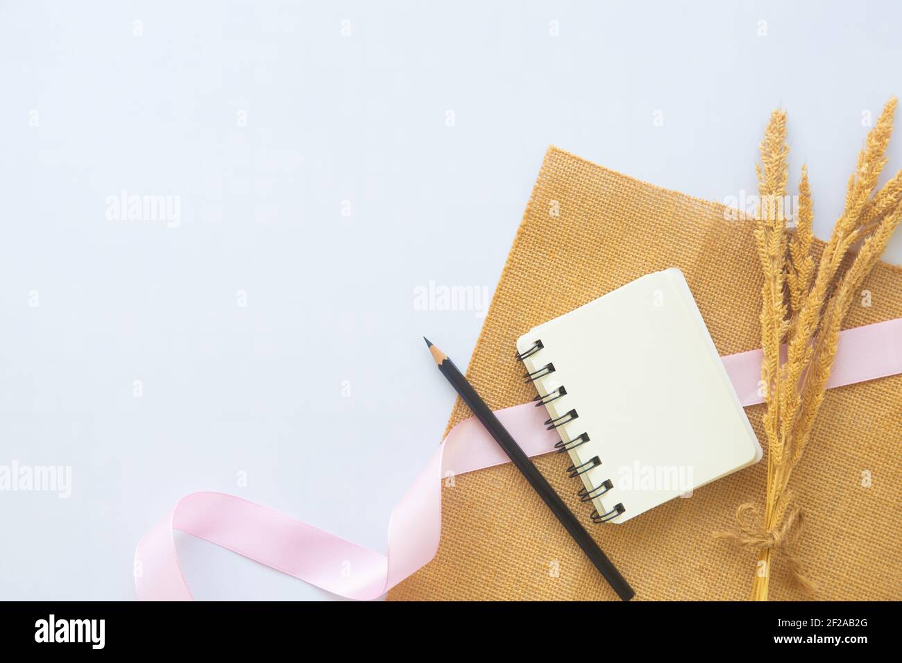 Blank white notebook with line or notepad and black pencil or pen near ...