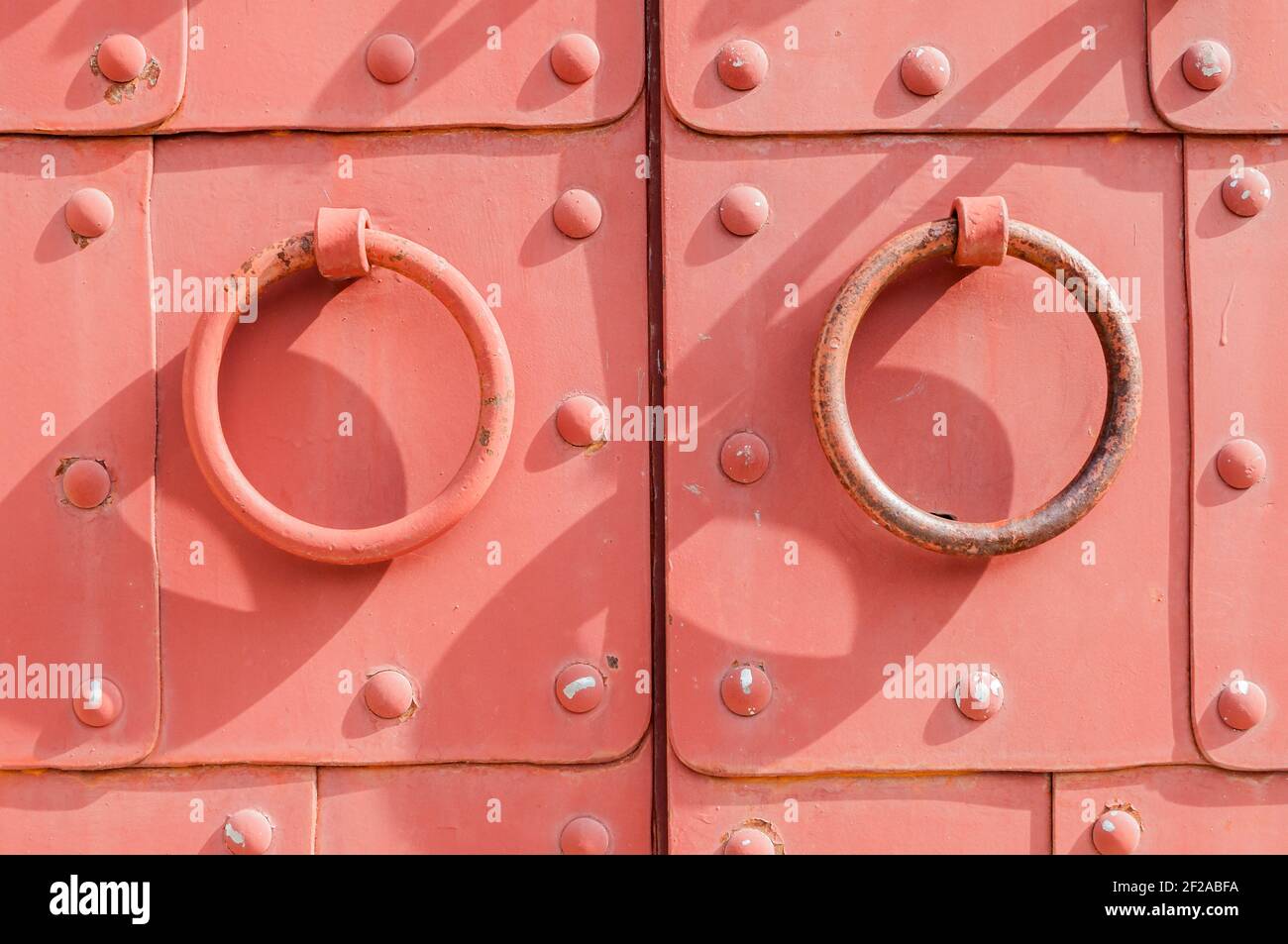 Metal red gates with rings door handles and metal rivets. Metal ...