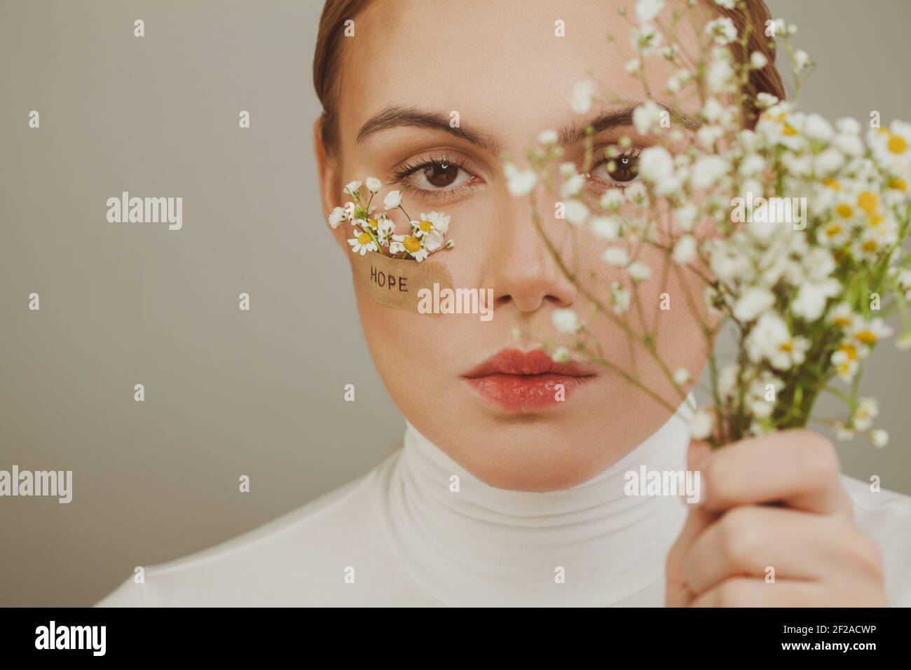 Hope. Young woman with flowers and Hope inscription on adhesive plaster ...