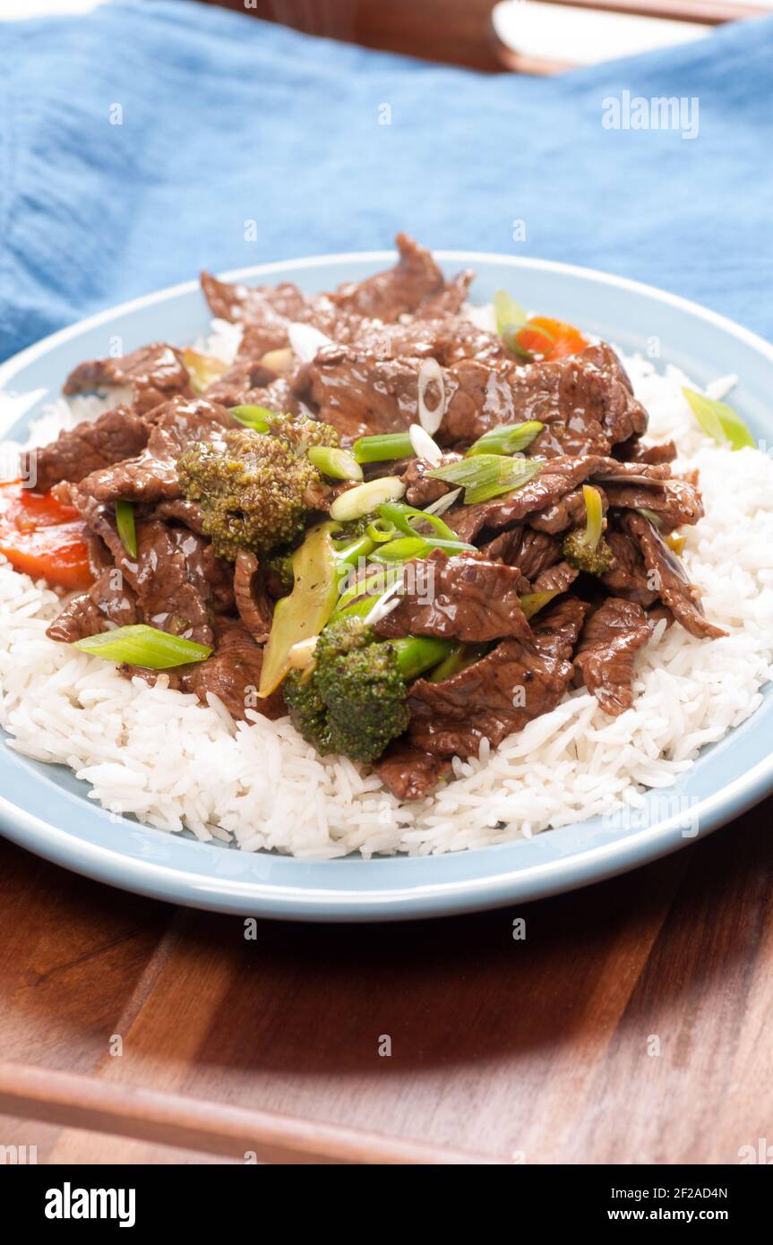 ginger beef stir fry over white rice and vegetables Stock Photo - Alamy