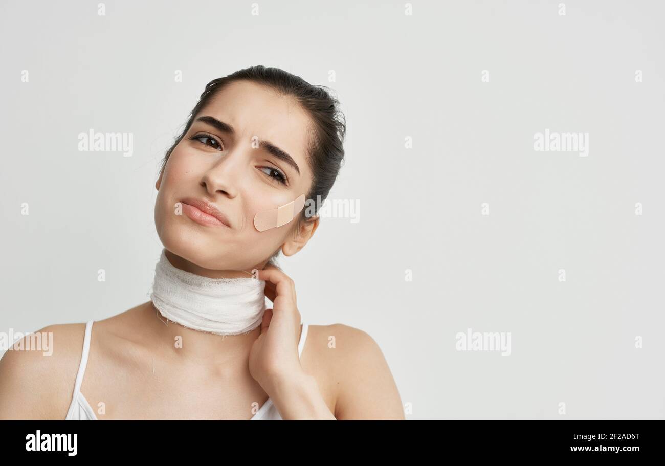 brunette with a bandaged neck holding her head health problems Stock ...