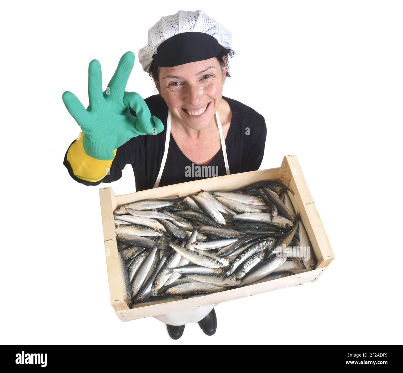 top view of fishmonger holding a box of sardine and making ok sign on ...