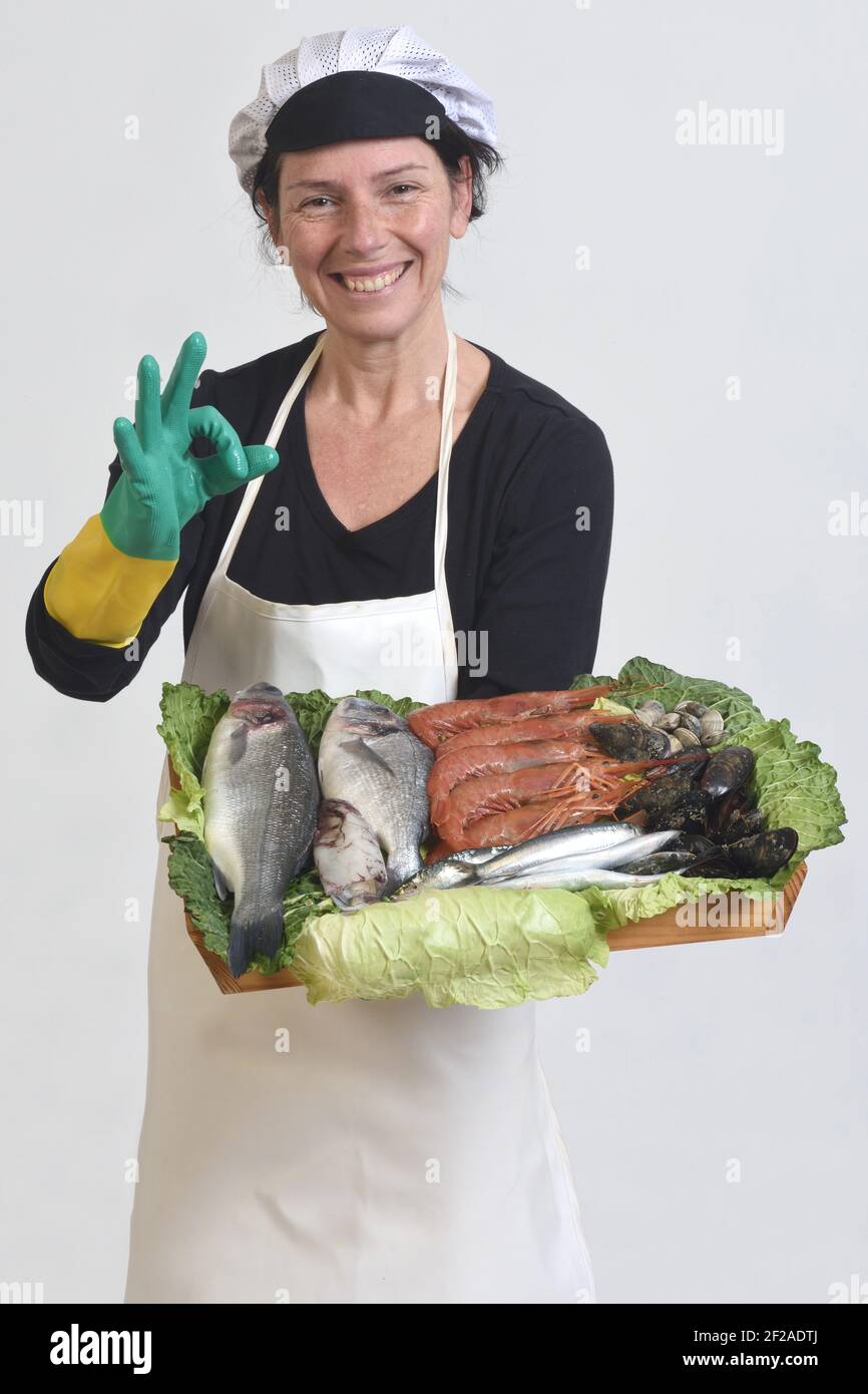 fishmonger showing a plate with fish and seafood and making a ok sign ...