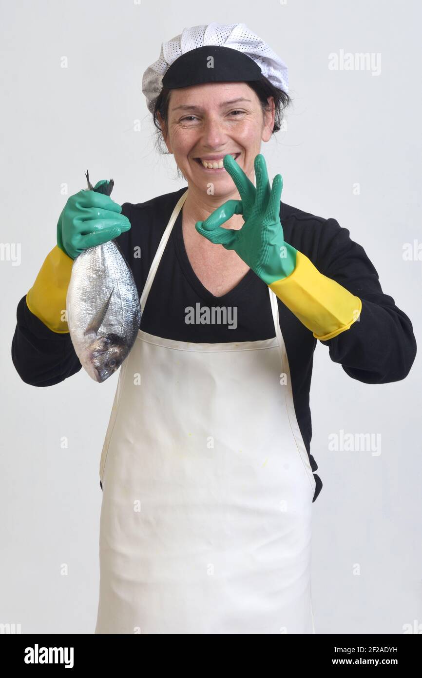 portrait of a fishmonger holding and ok sign at a sea bream on white ...