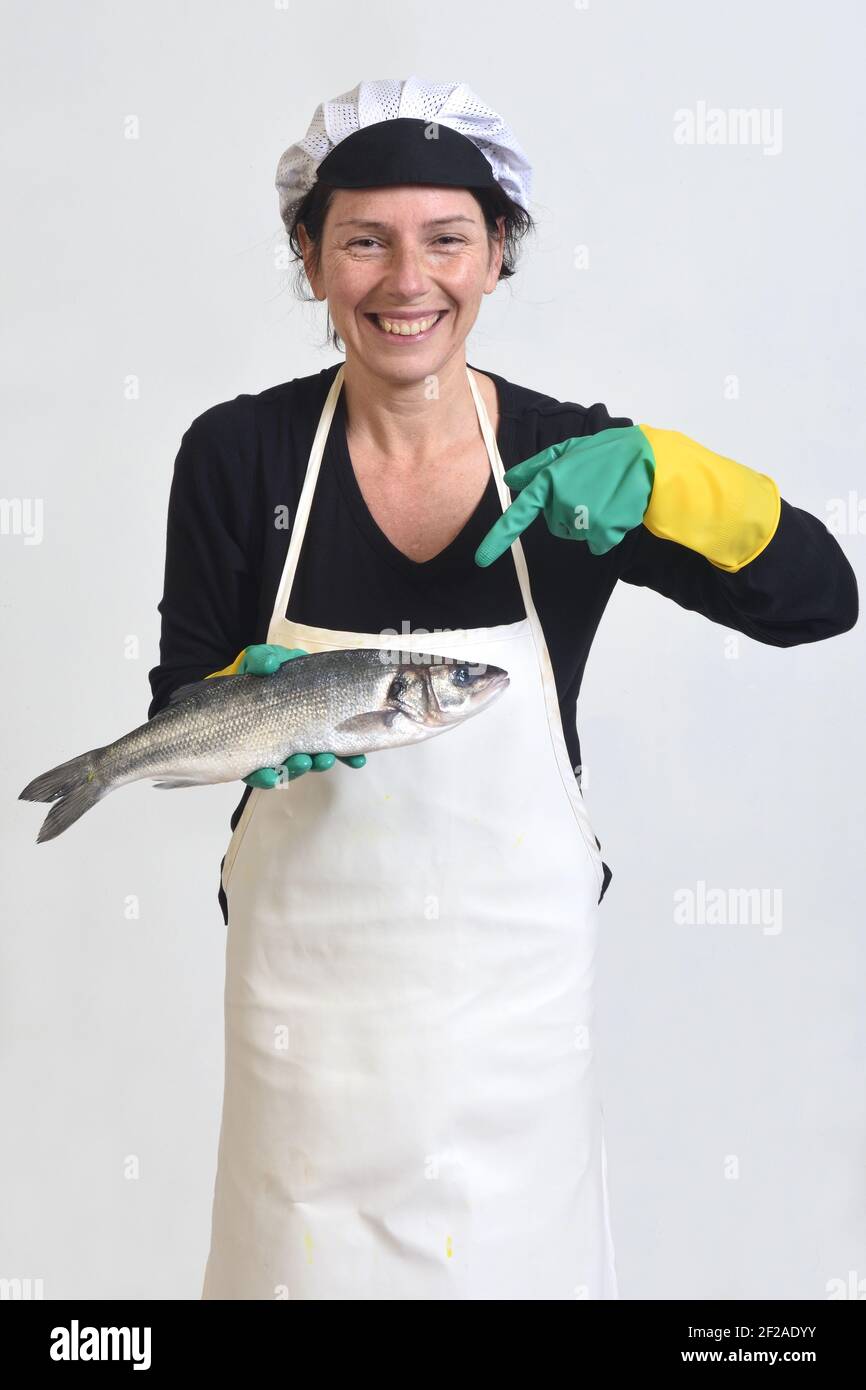 a fishmonger holding and pointing a finger at a sea bass on white ...