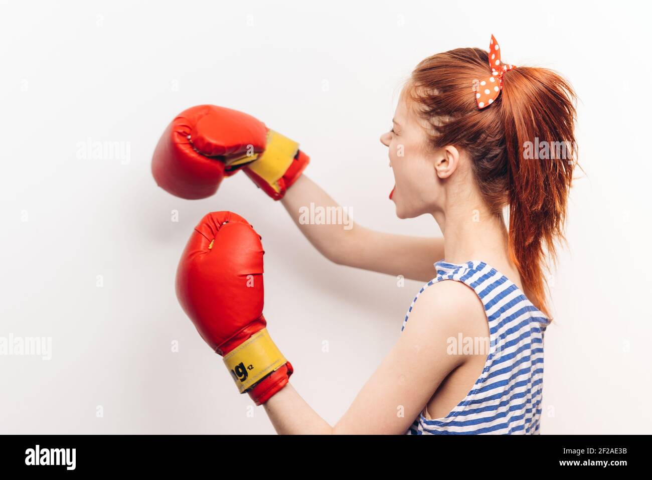 aggressive woman doing sports boxing striped t-shirt hairstyle model ...