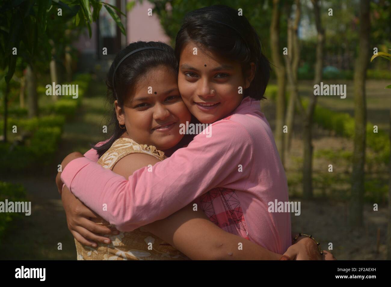 Close up of two beautiful teenage Indian Bengali girls hugging each ...
