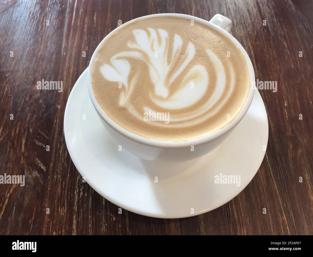 A cup of caffe latte with latte art on surface Stock Photo - Alamy