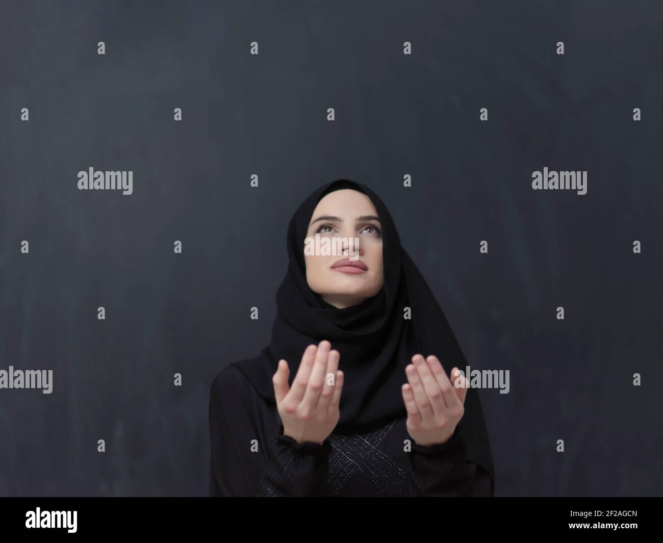 Portrait of young Muslim woman making dua. Arabian girl wearing abaya ...