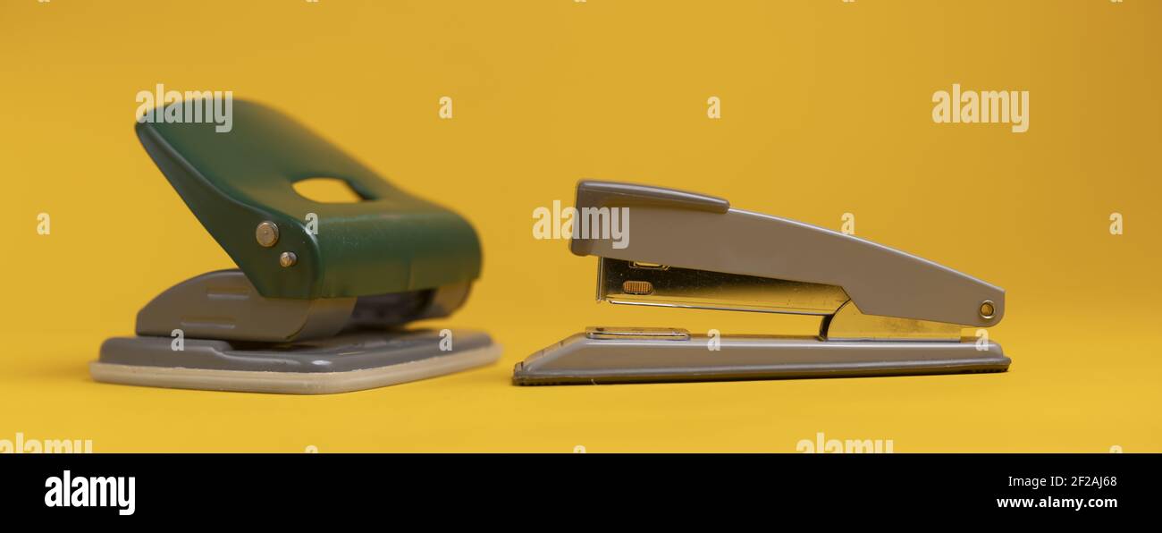 Office tools with a stapler and perforator still life against a ...