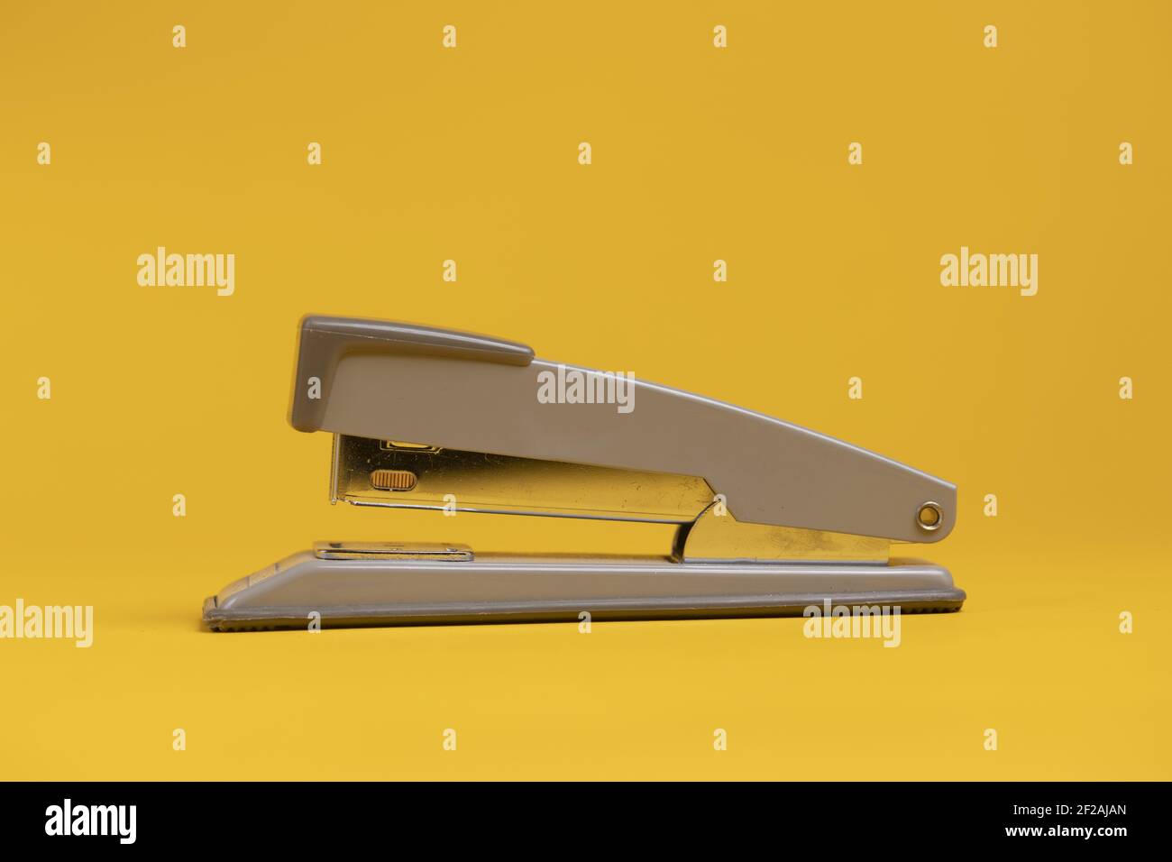 Stapler office tool still life against a seamless solid yellow ...