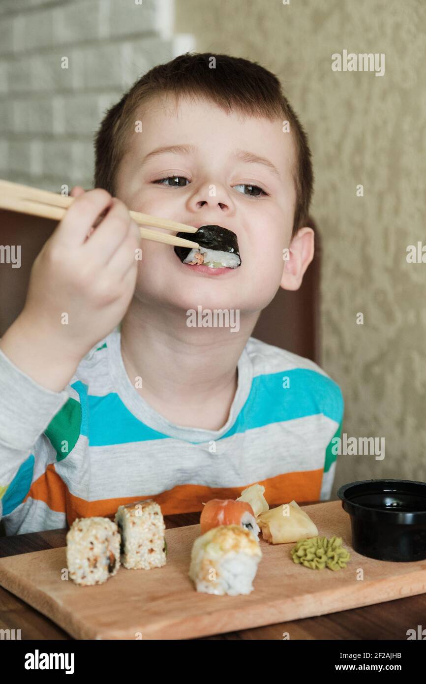 Child Eat Sushi Rolls At Home. Happy boy ready for eating sushi Stock ...