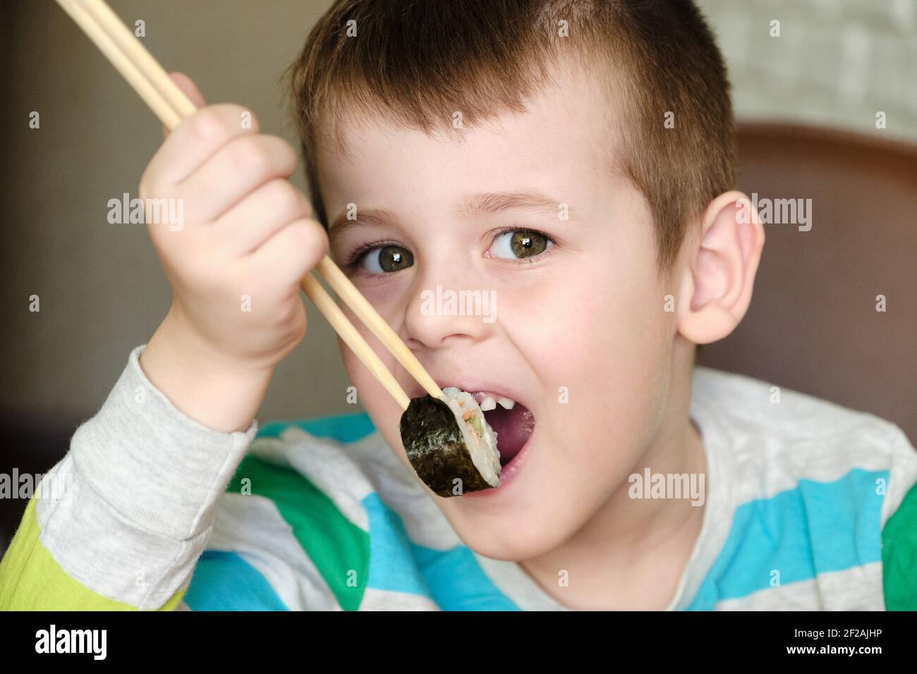 Child Eat Sushi Rolls At Home. Happy boy ready for eating sushi Stock ...