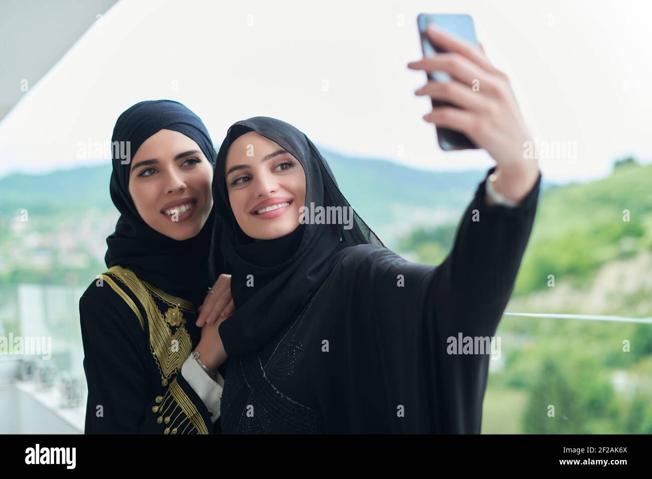 Portrait of young muslim women taking selfie on the balcony Stock Photo ...