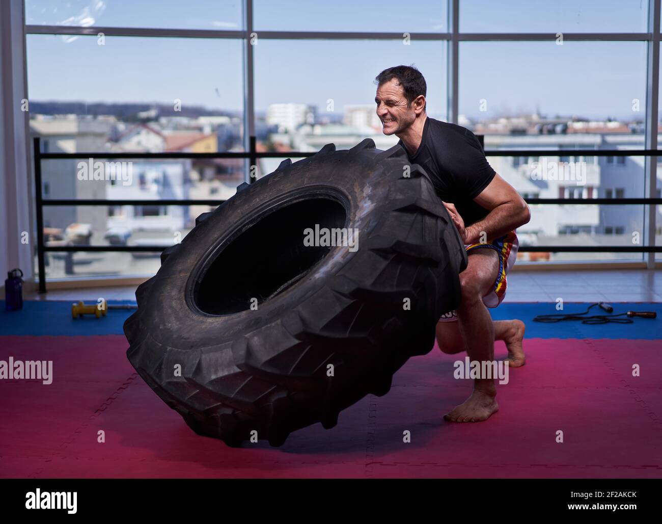 Kickboxing fighter conditioning training, tire flips in the gym Stock ...