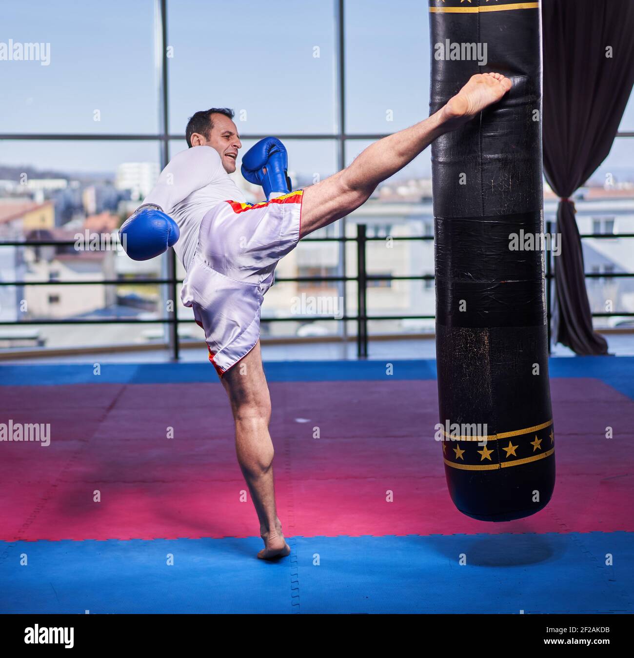 Kickboxing fighter hitting the heavy bag in the gym, training for ...