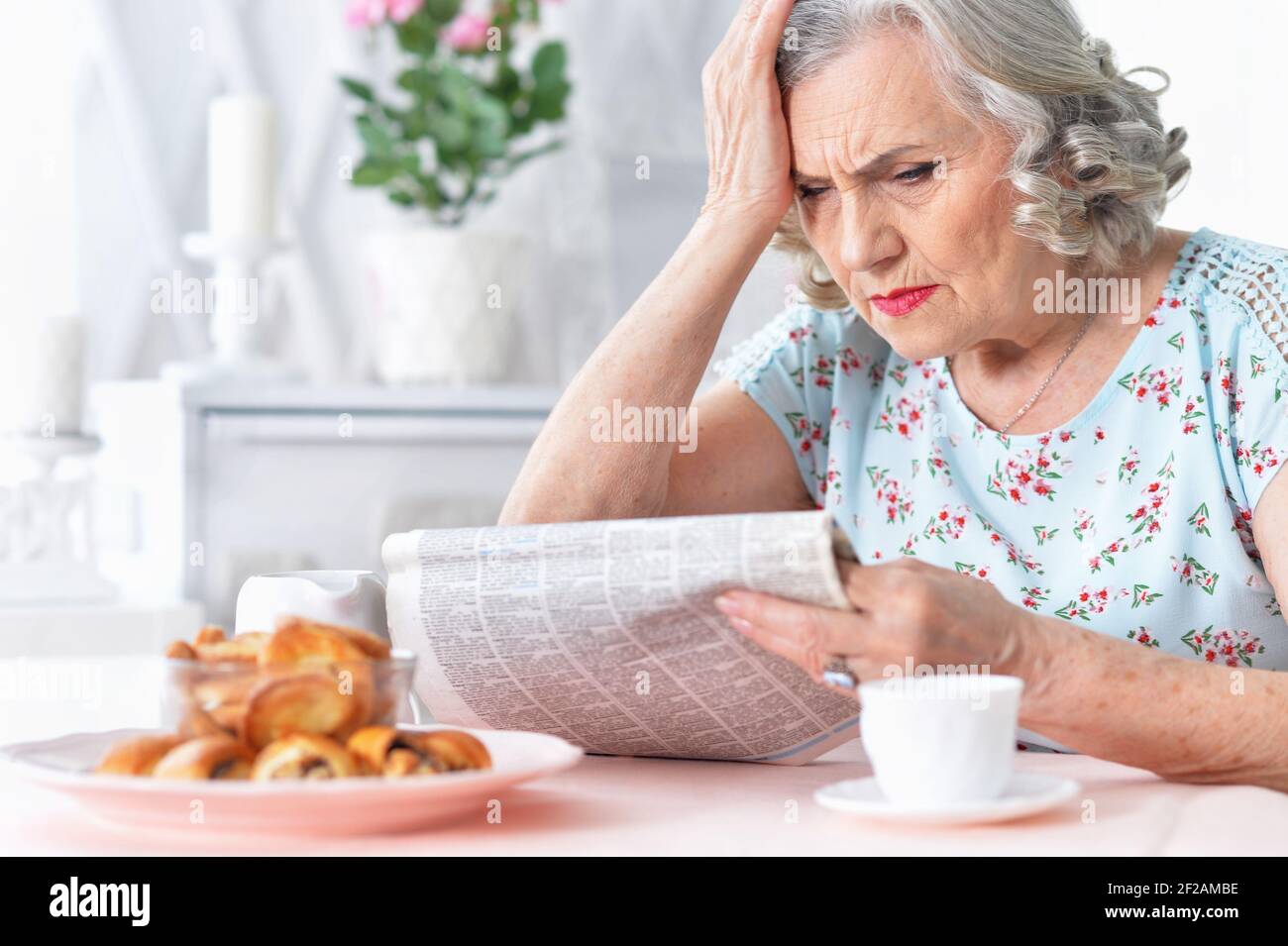 Portrait of thoughtful aged woman reading newspaper Stock Photo - Alamy