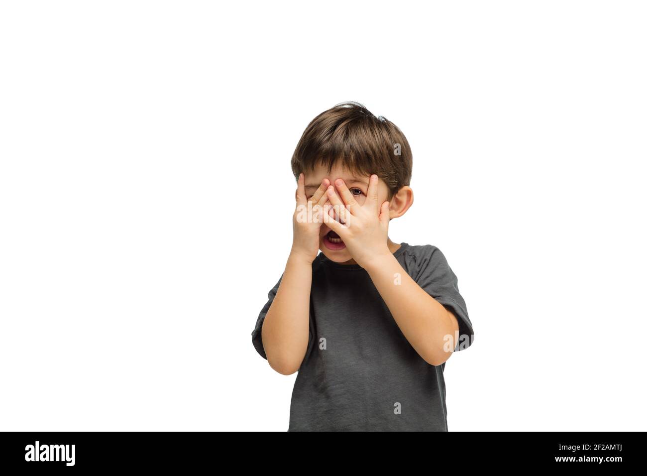 Hiding face in hands. Happy, smiley little caucasian boy isolated on ...