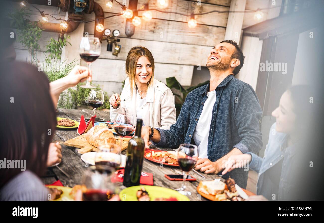 Young friends having fun drinking red wine on balcony at house dinner ...