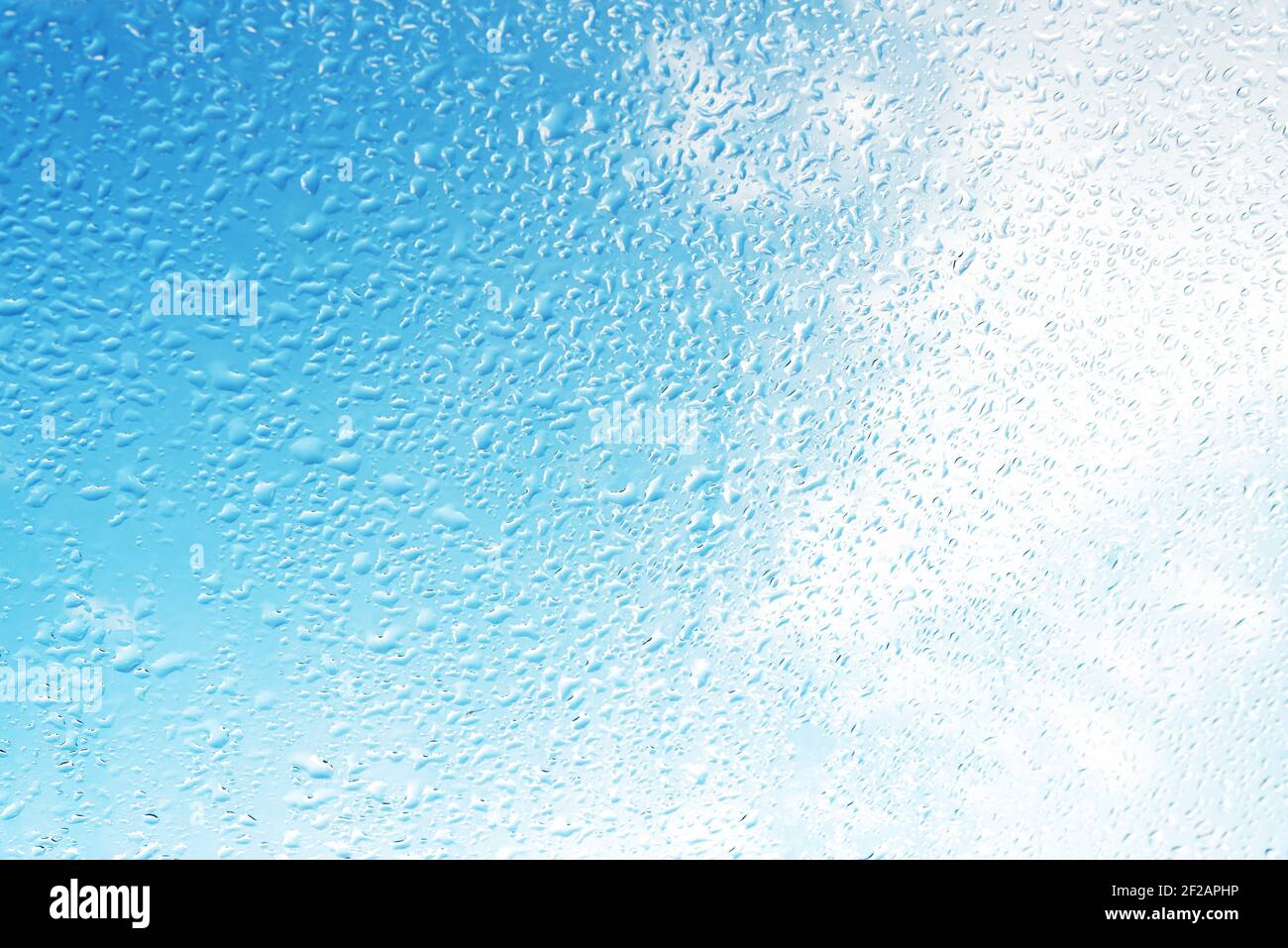 Rain drops on surface of the window glass with sky cloud background ...