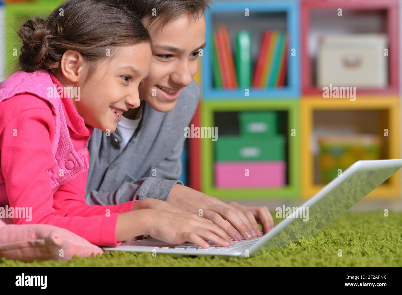 Happy brother and sister using modern laptop Stock Photo - Alamy