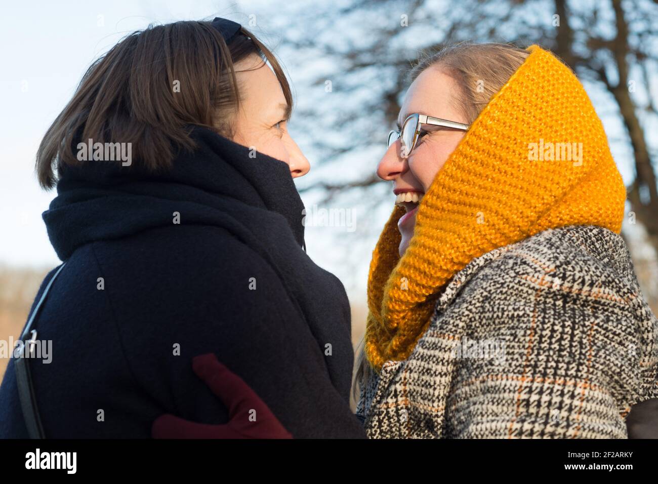 Two women look at each other and smile in nature Stock Photo - Alamy