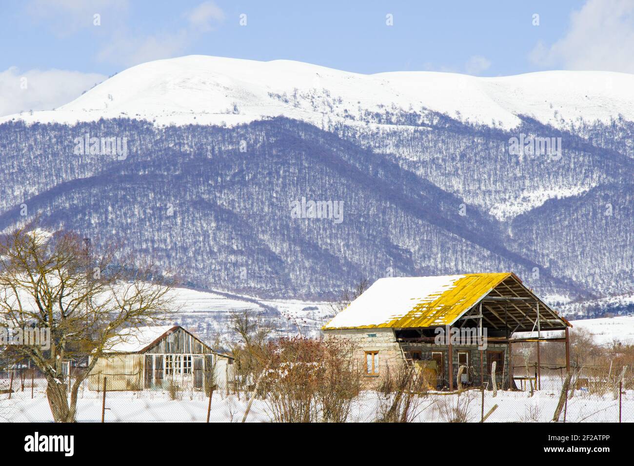 An old cottage in a village in a snowy landscape in Georgia Stock Photo ...