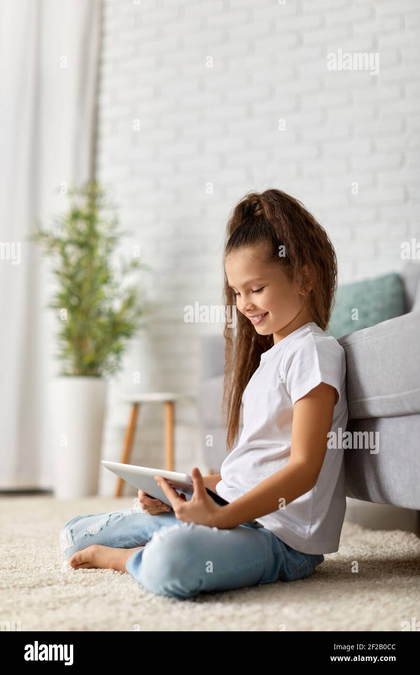 little child girl using digital tablet at home. kid using gadgets for ...