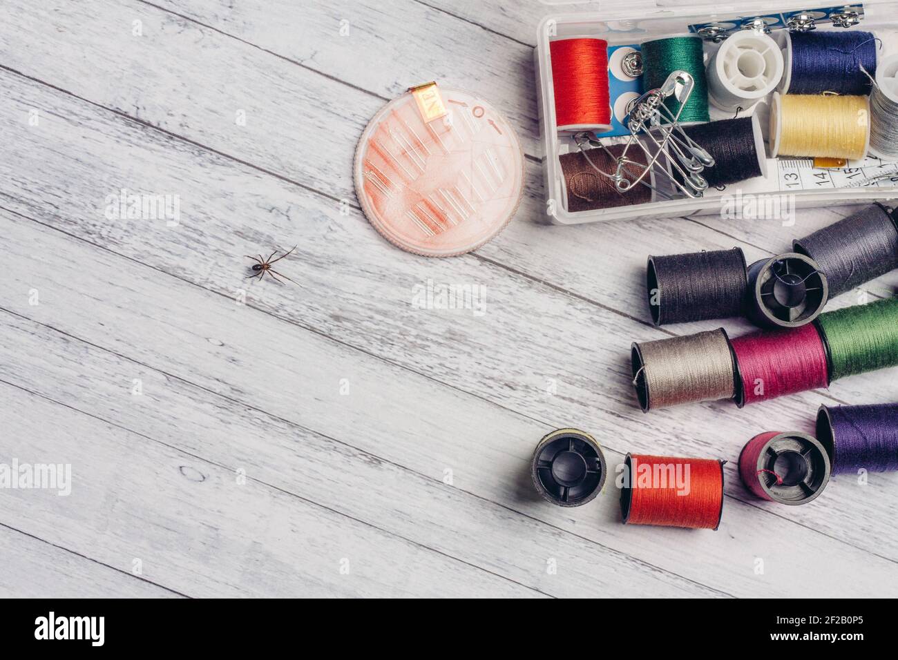 multicolored thread pins on a wooden table sewing accessories Copy ...