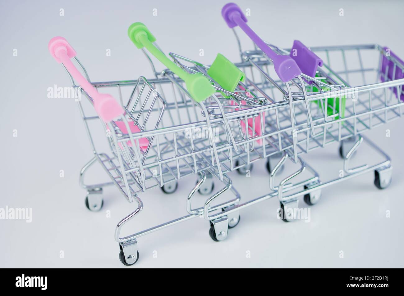 three miniature shopping carts in a row on a white background Stock ...