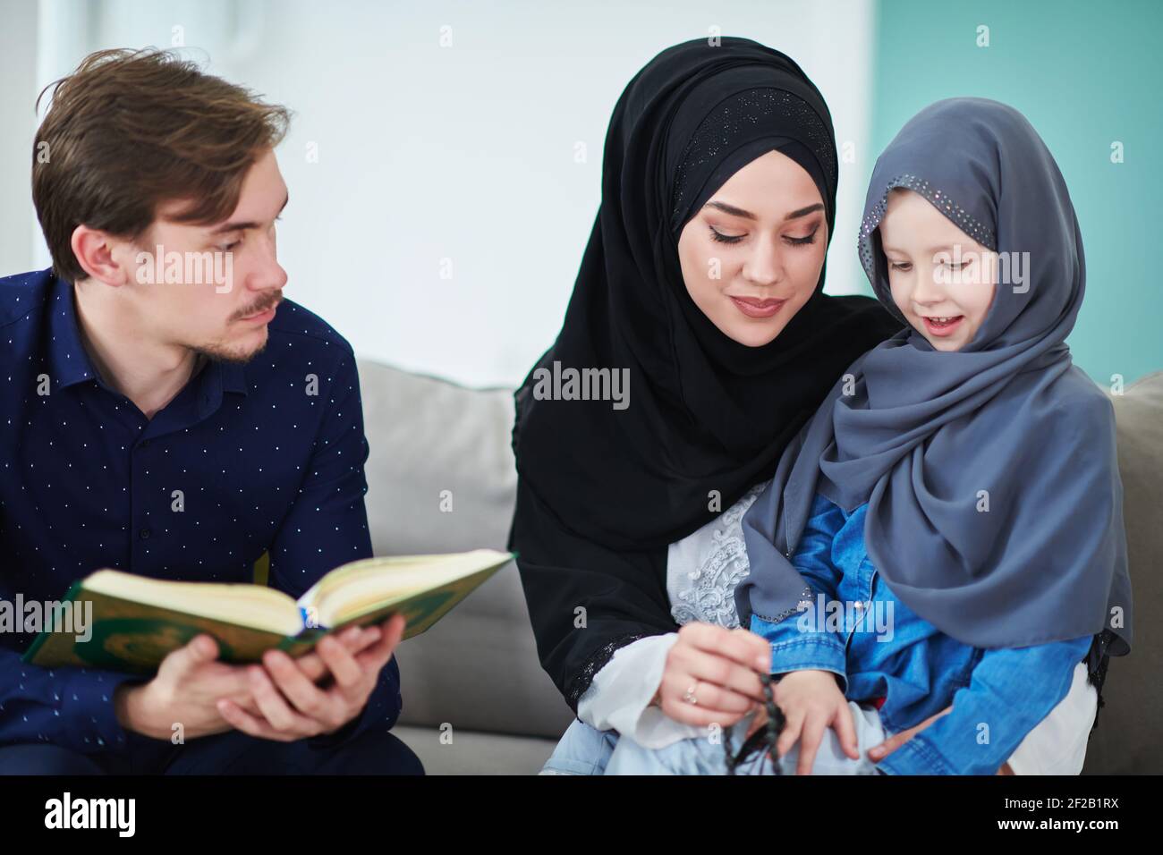 Young muslim family reading Quran during Ramadan Stock Photo - Alamy