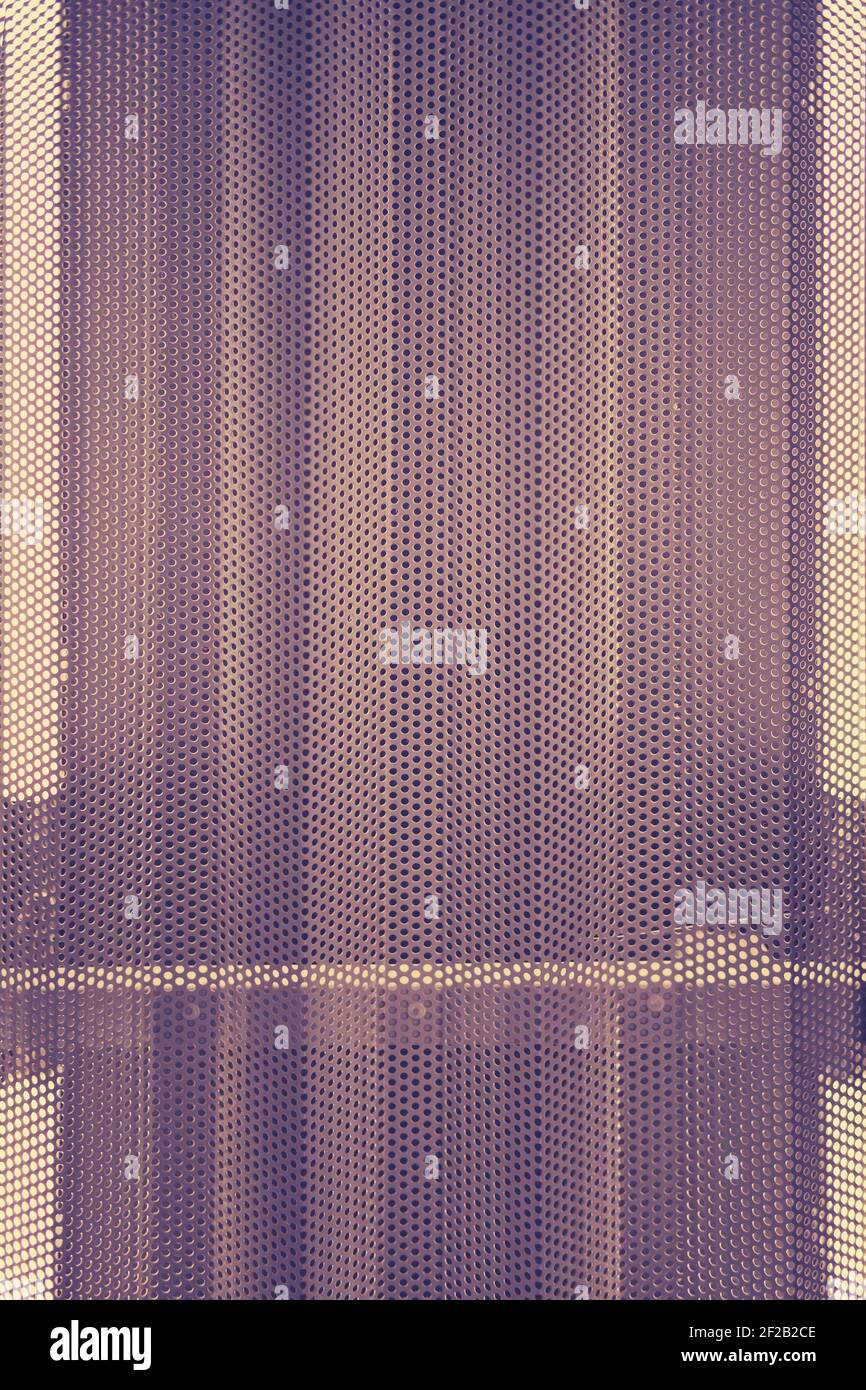 The lattice texture of metal with round uniform holes and a light bulb ...